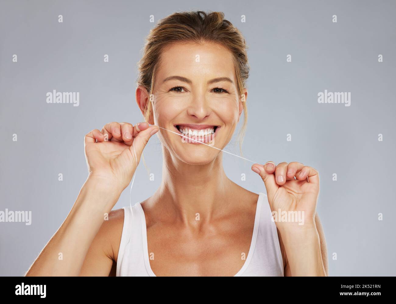Dental, healthcare and oral hygiene with a woman flossing her teeth and ...