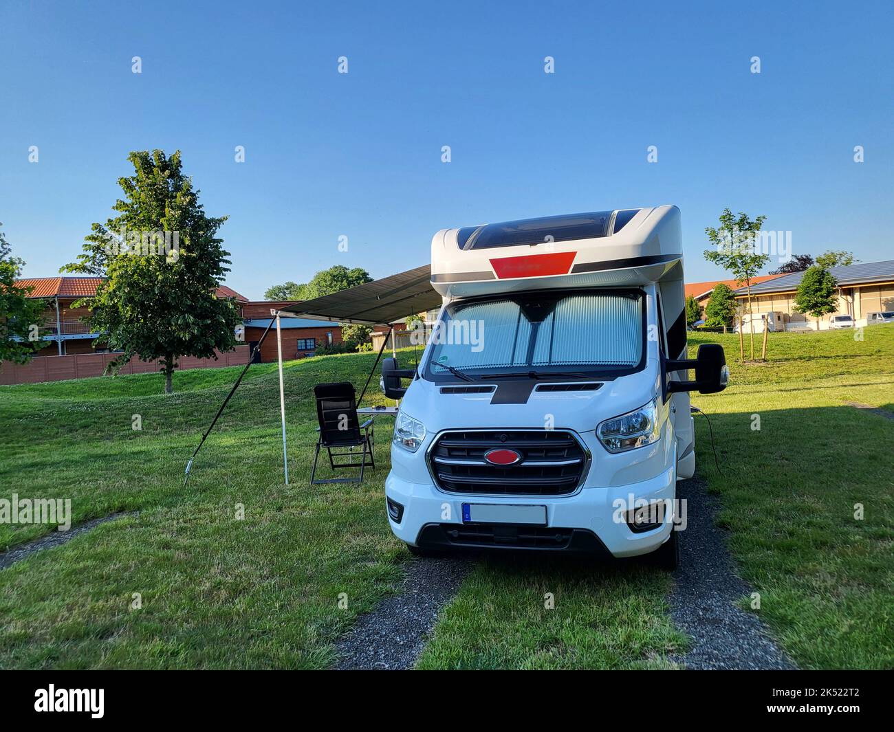 Mobile home with awning and awning and camping table with chairs on the ...
