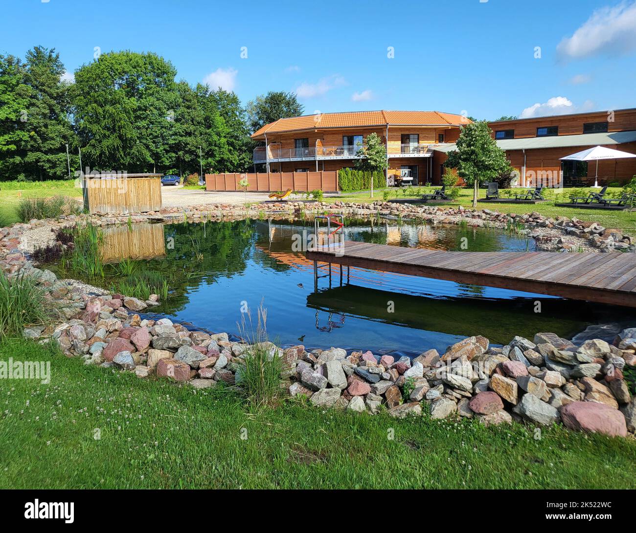 Natural pond of a natural pool with wooden bridge and entrance ...