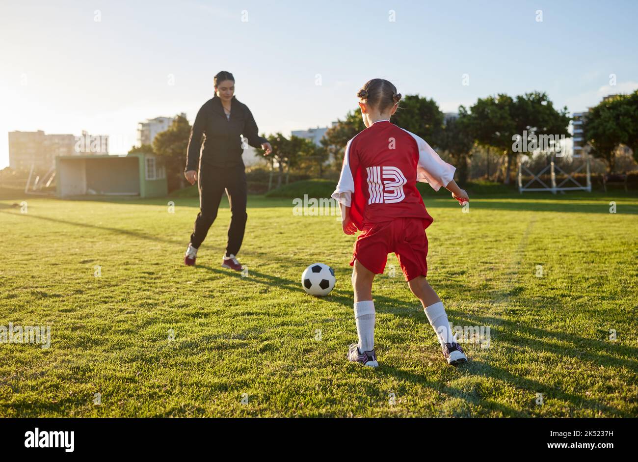 Soccer, coach and child sport on a outdoor school field with a ball for ...