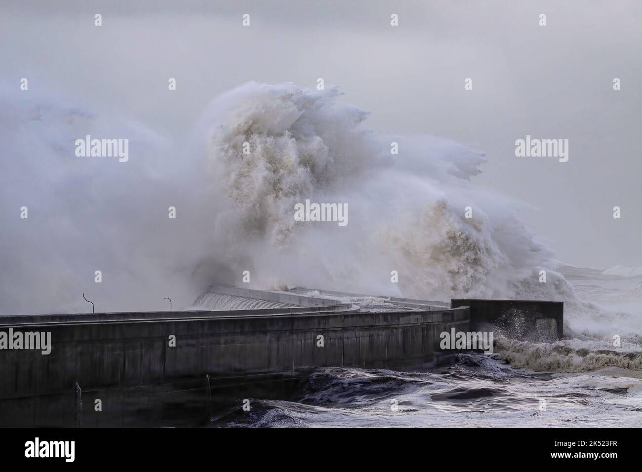 Huge stormy wave splash in the middle of moisture. Light from overcast ...