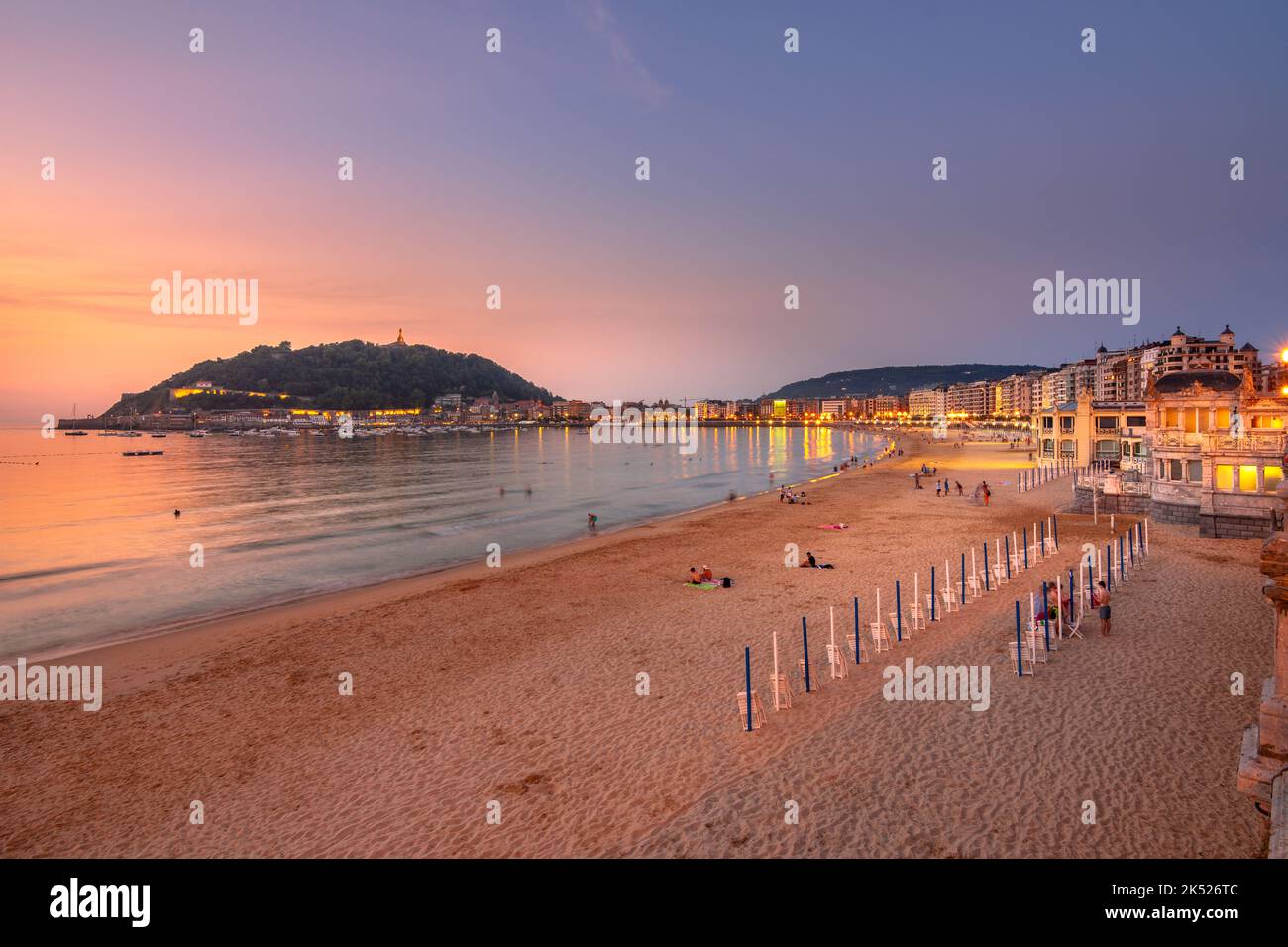 Nice beach with the old town of San Sebastian, Spain at gorgeous sunset ...