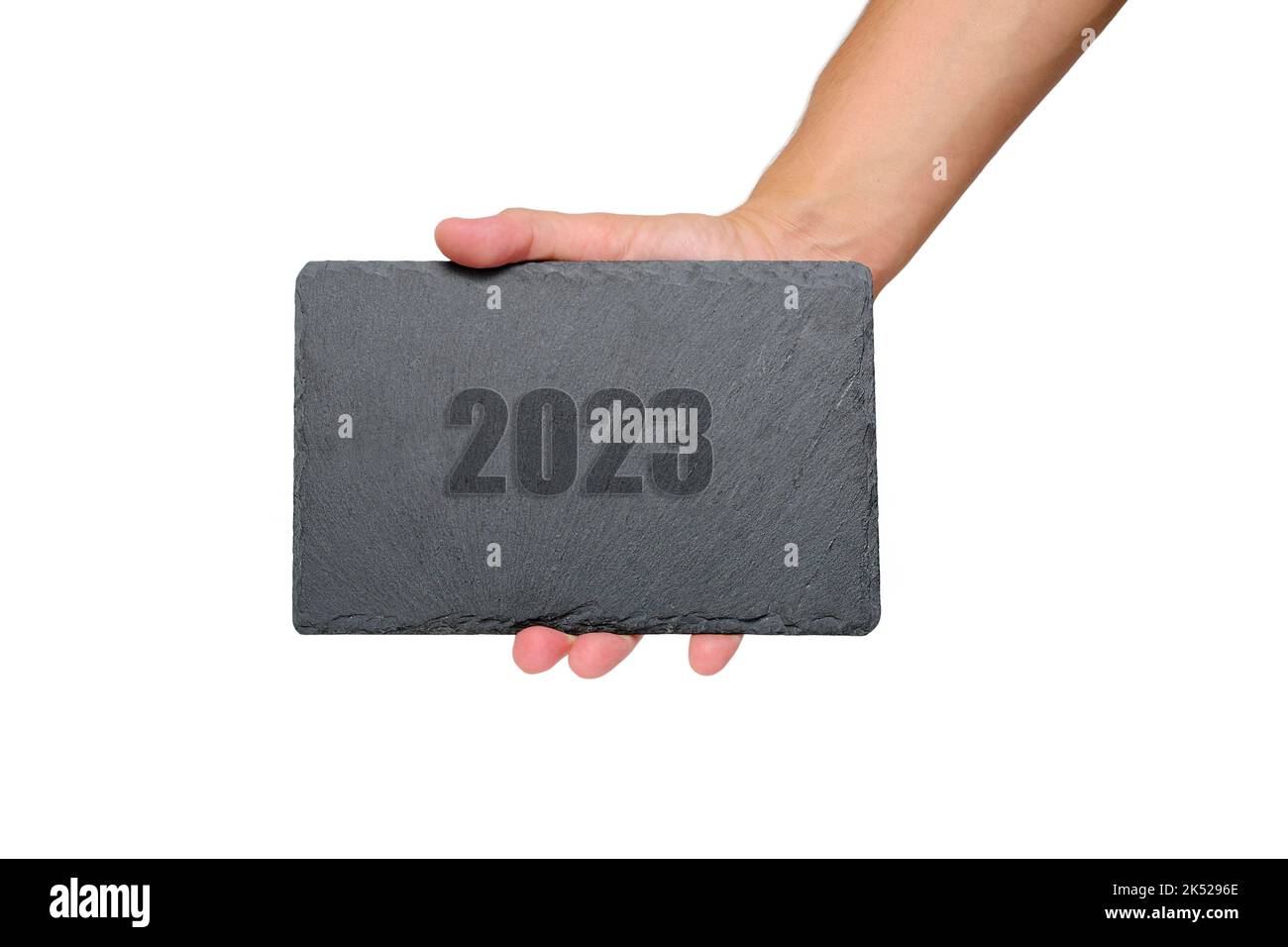Gray stone plaque in his hand with inscription 2023 Stock Photo - Alamy