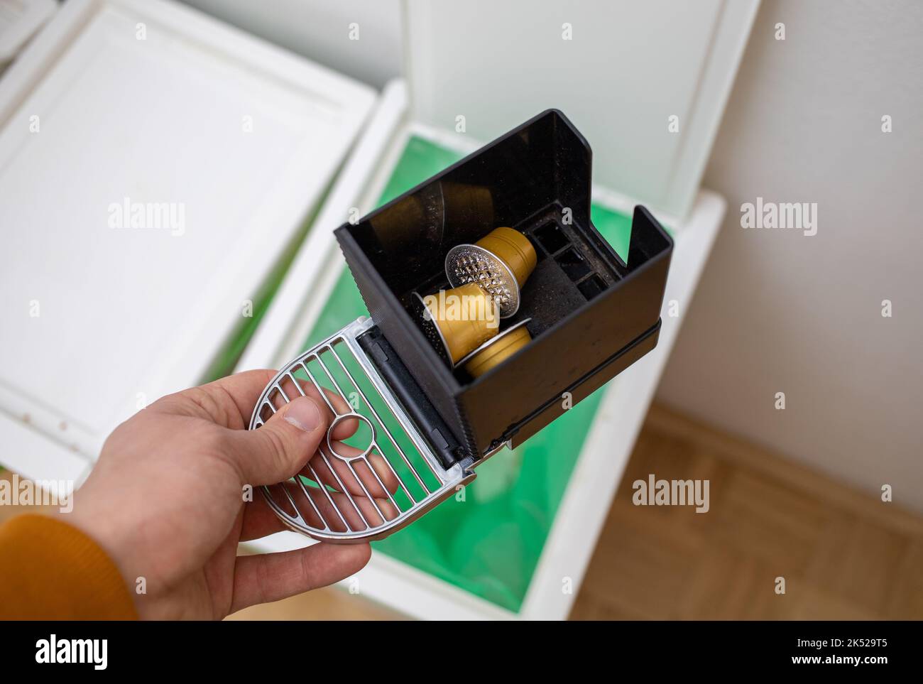 throwing coffee capsules in the trash bin Stock Photo - Alamy