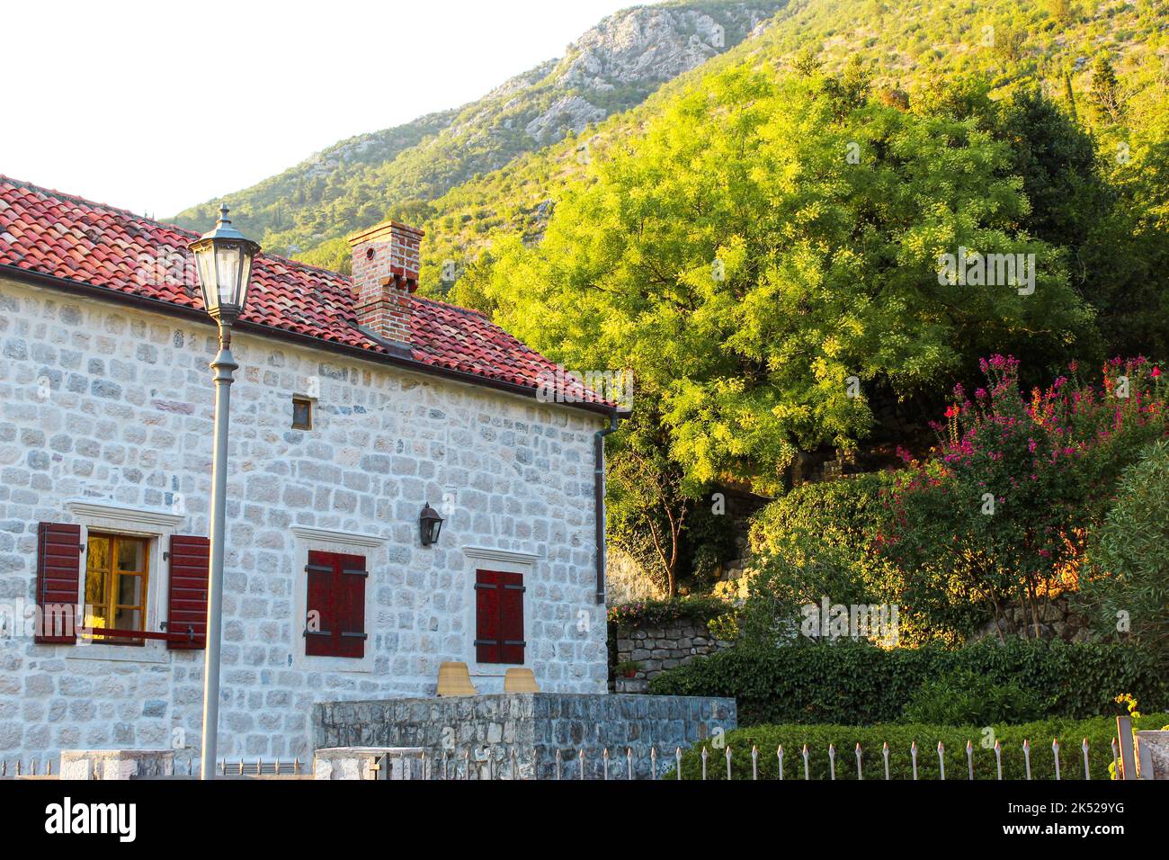 White house with red roof, brown windows in the garden. Popular tourist ...