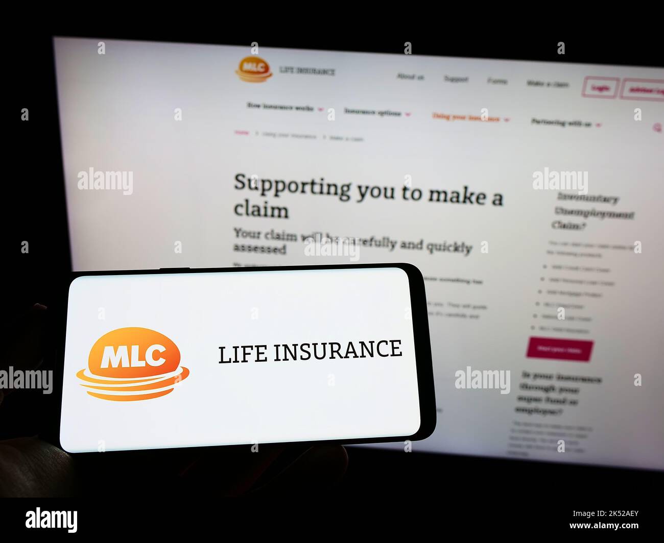 Person holding mobile phone with logo of Australian financial company ...