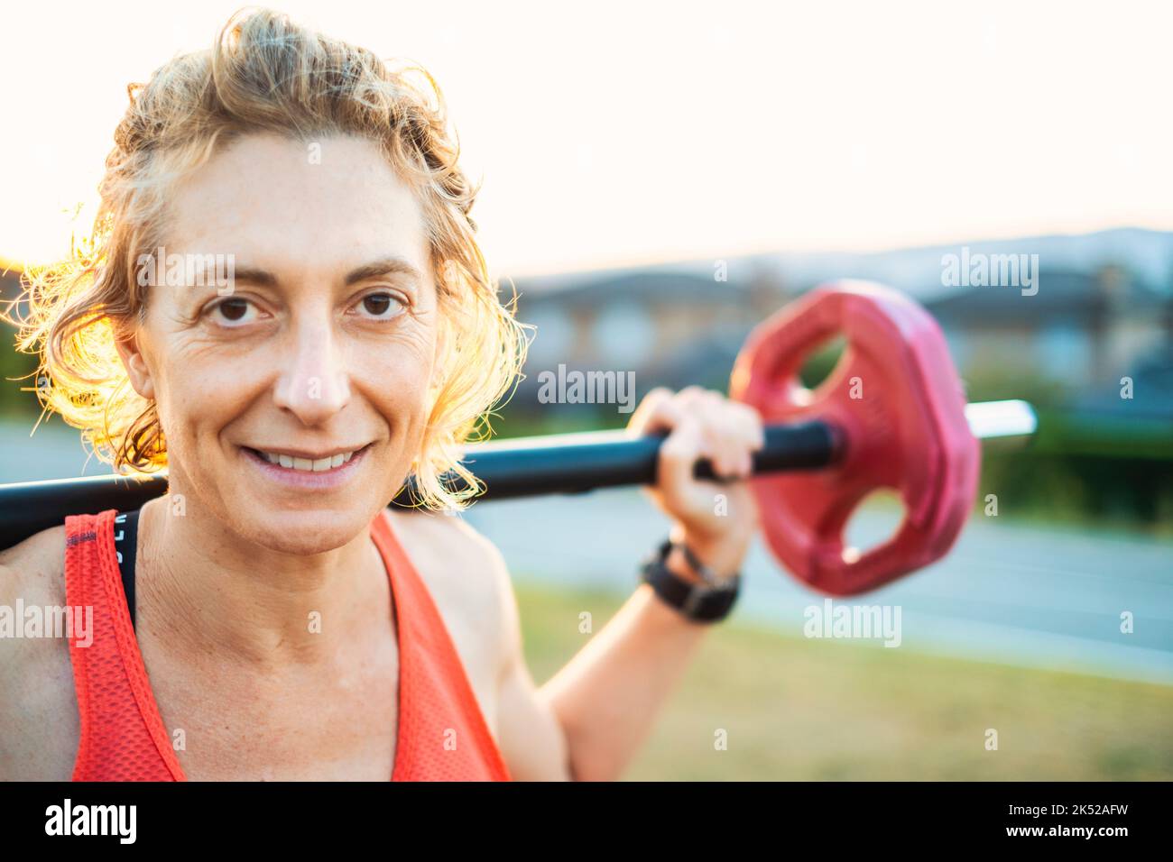 Real young mature caucasian woman in a sport wear in the park with a ...