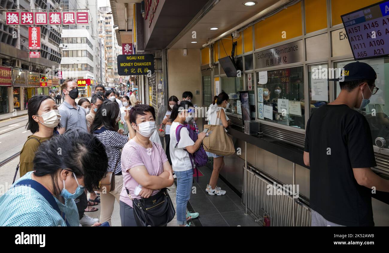 People queue up for change money outside a currency exchange shop at ...
