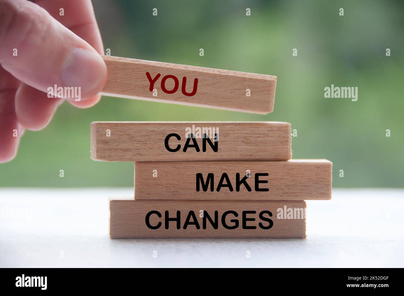 Hand stacking wooden block with text You Can Make Changes ...