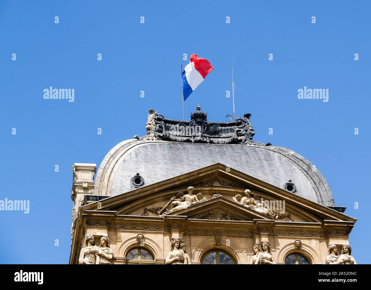 Flag of France over historic building with intricate figurines and ...