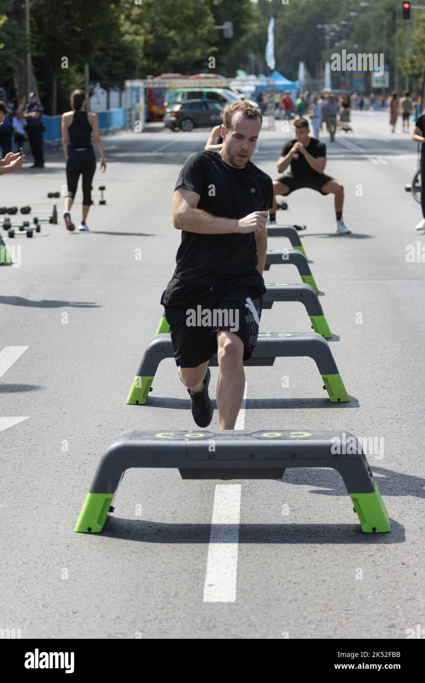 People doing sports in the street with jumps, races, weights and on ...