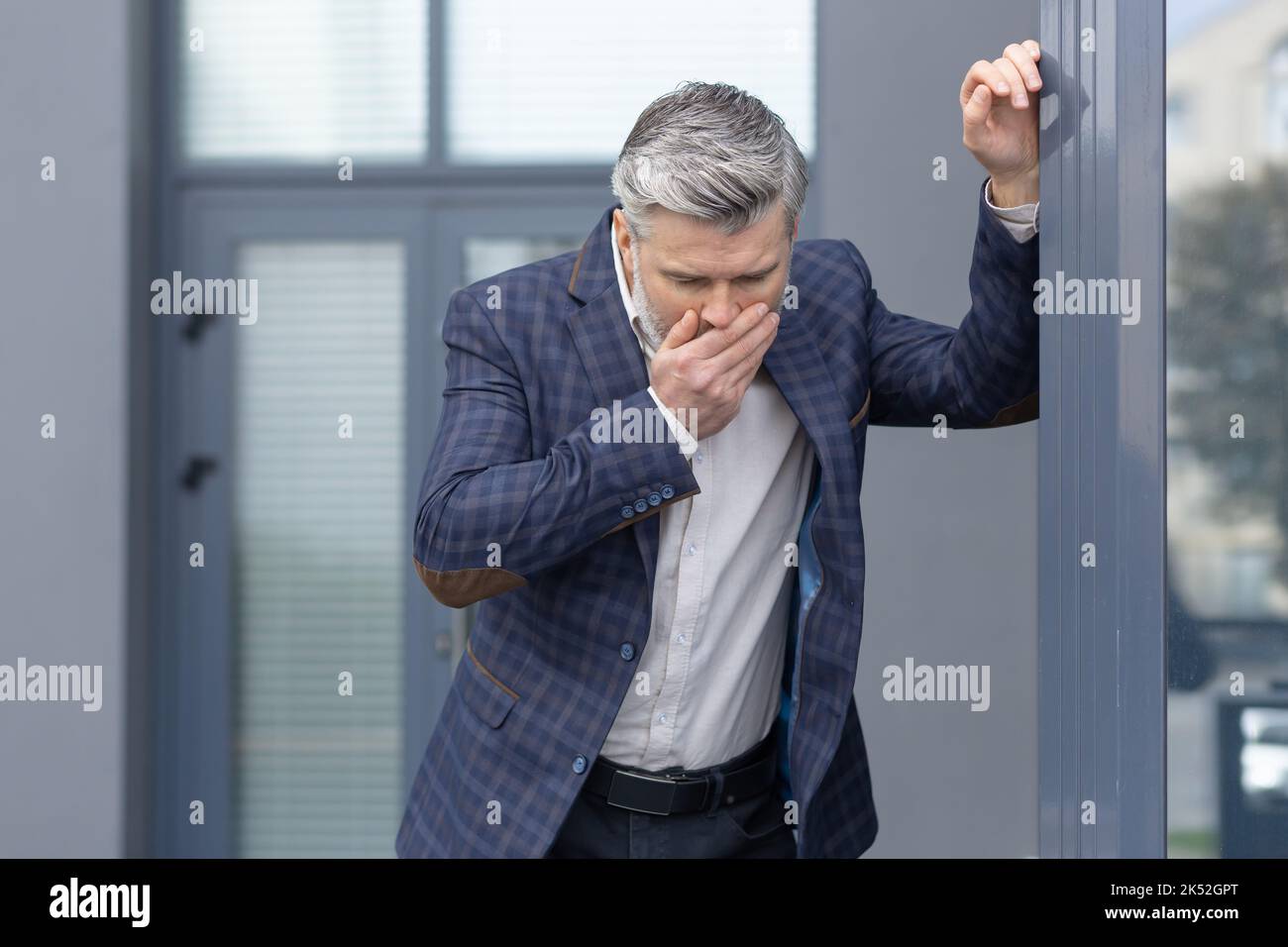 Senior gray haired businessman sick outside office modern building ...