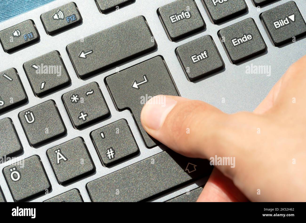 Man pressing the enter key on a modern computer keyboard, top view ...