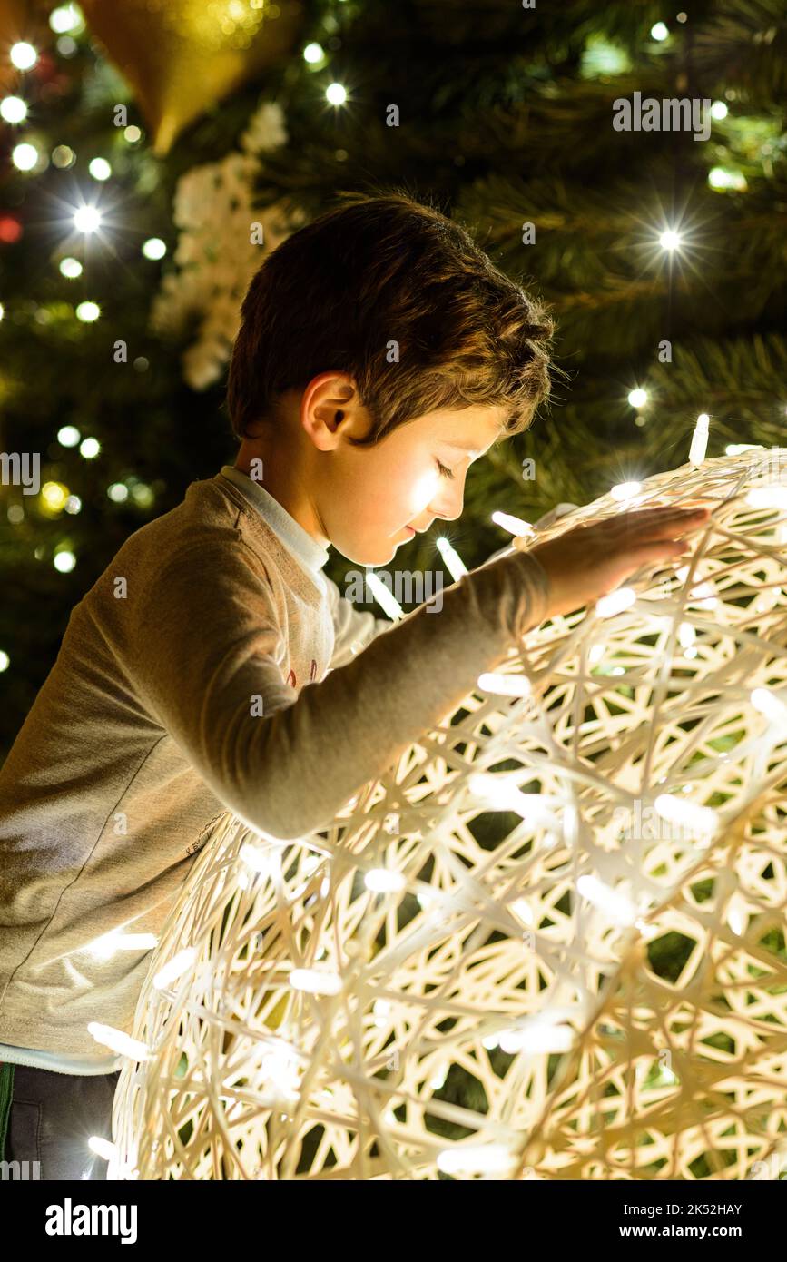 Christmas scene of a child looking at a big ball made of small white ...