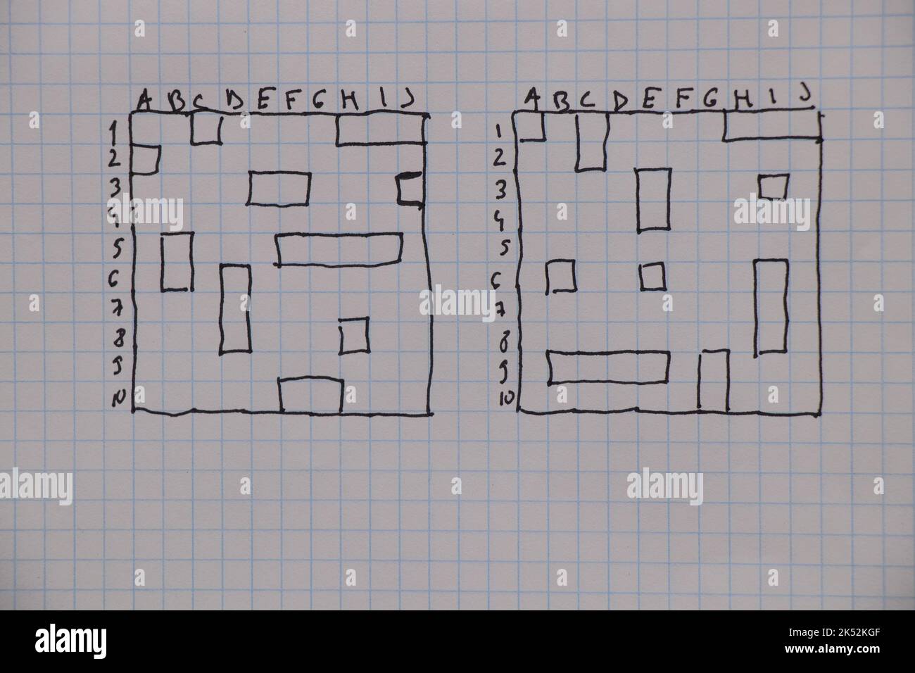 sea battle game, hand-drawn with a pen in a white notebook, rest on a ...