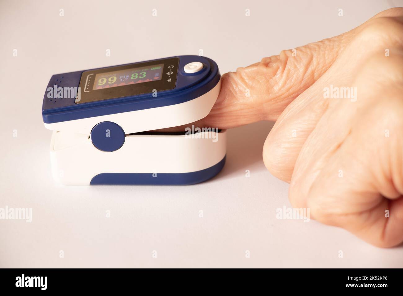 pulse oximeter on the finger of a woman on an isolated background ...