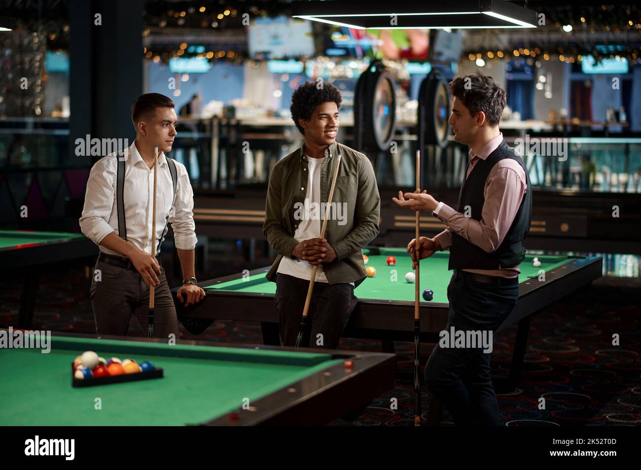 Company of handsome young guy playing in pool Stock Photo - Alamy