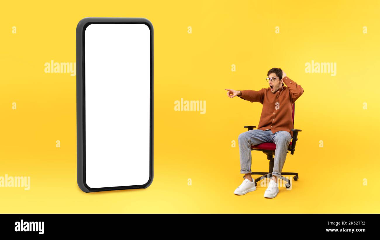 Man Pointing Finger Aside At Huge Phone Screen, Yellow Background Stock ...