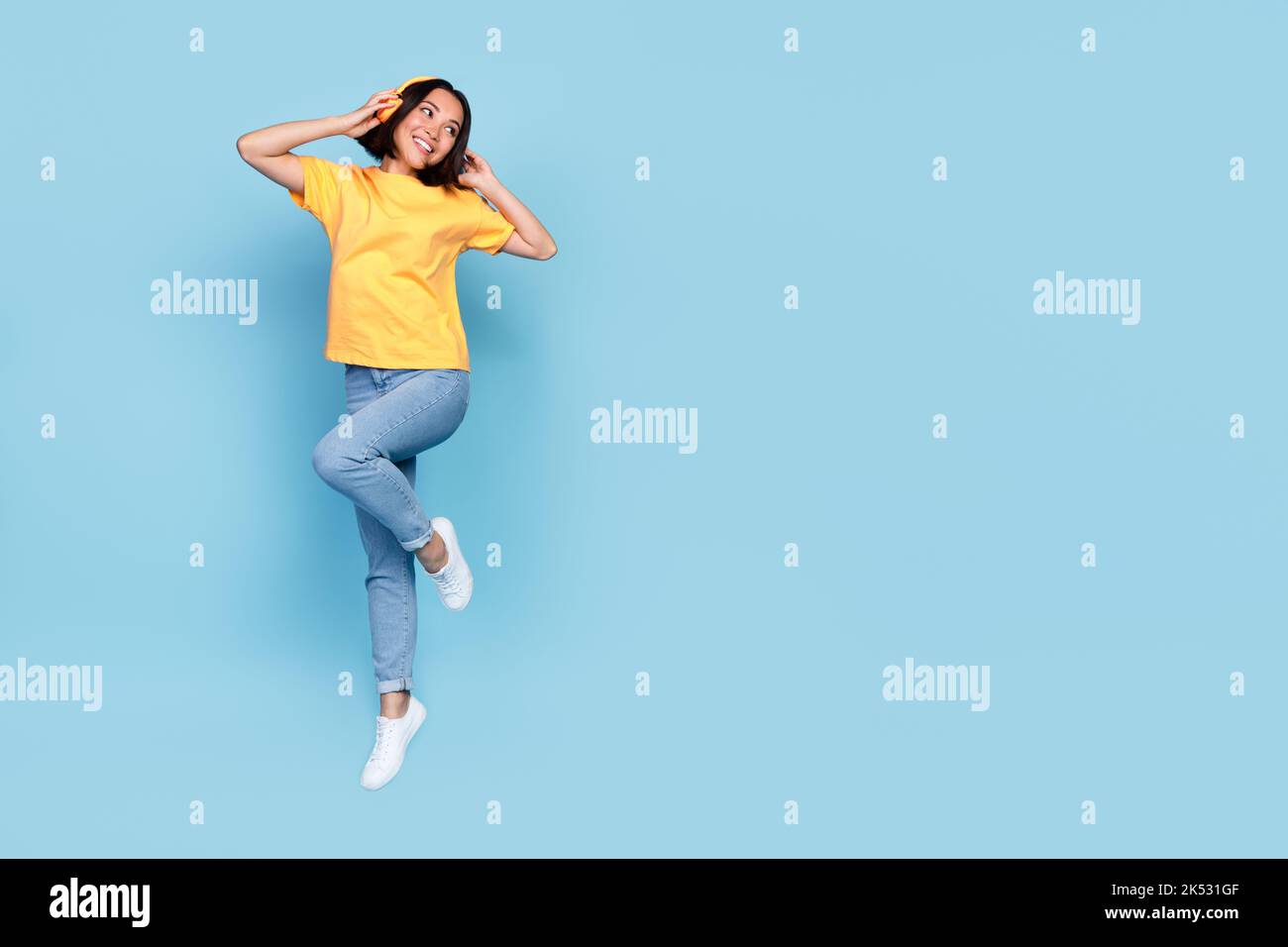 Full length photo of young korean girl jump air trampoline listen ...