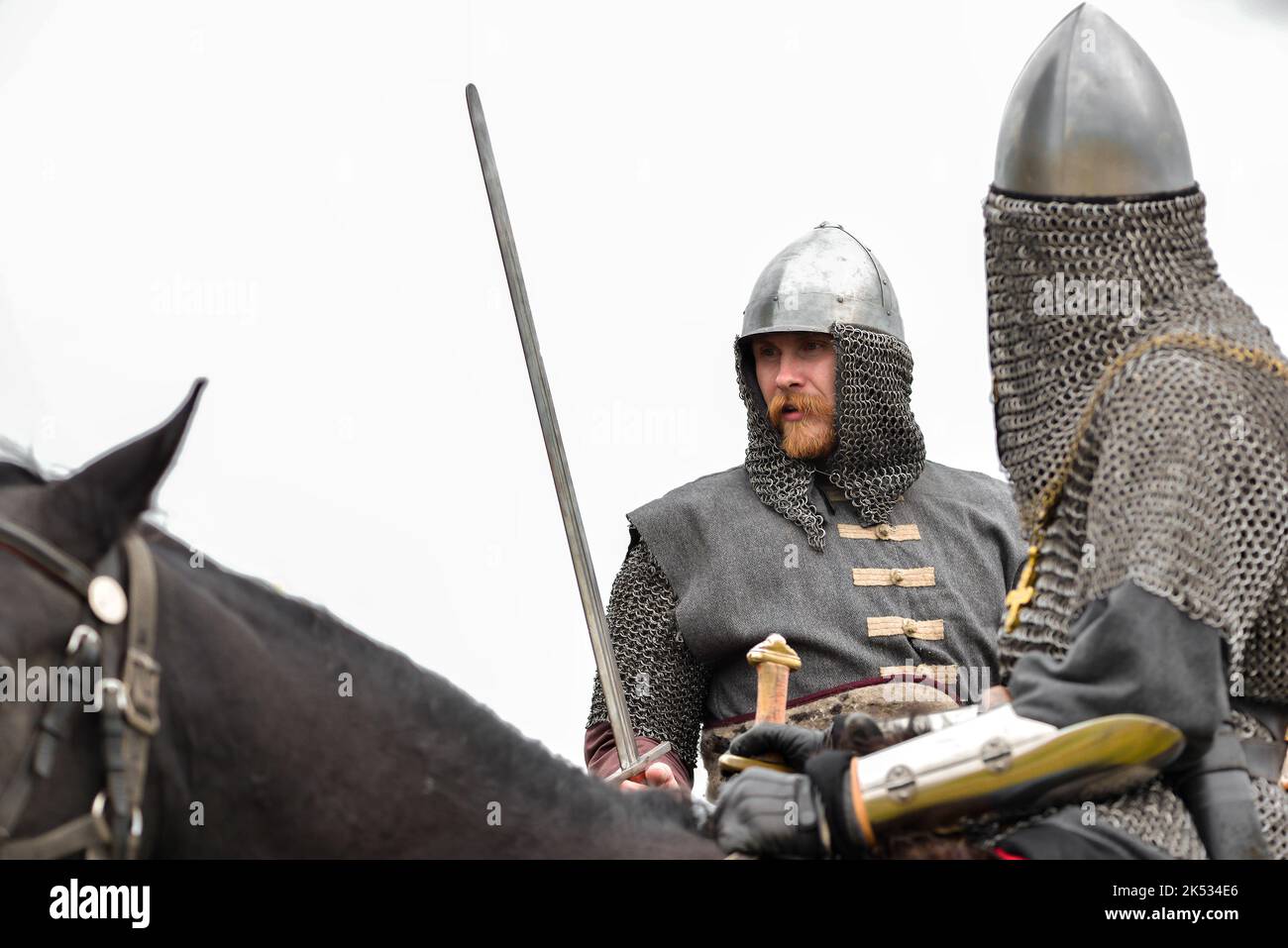 Horsemans in chain mail armor and fabric clothing hold in hands weapons ...