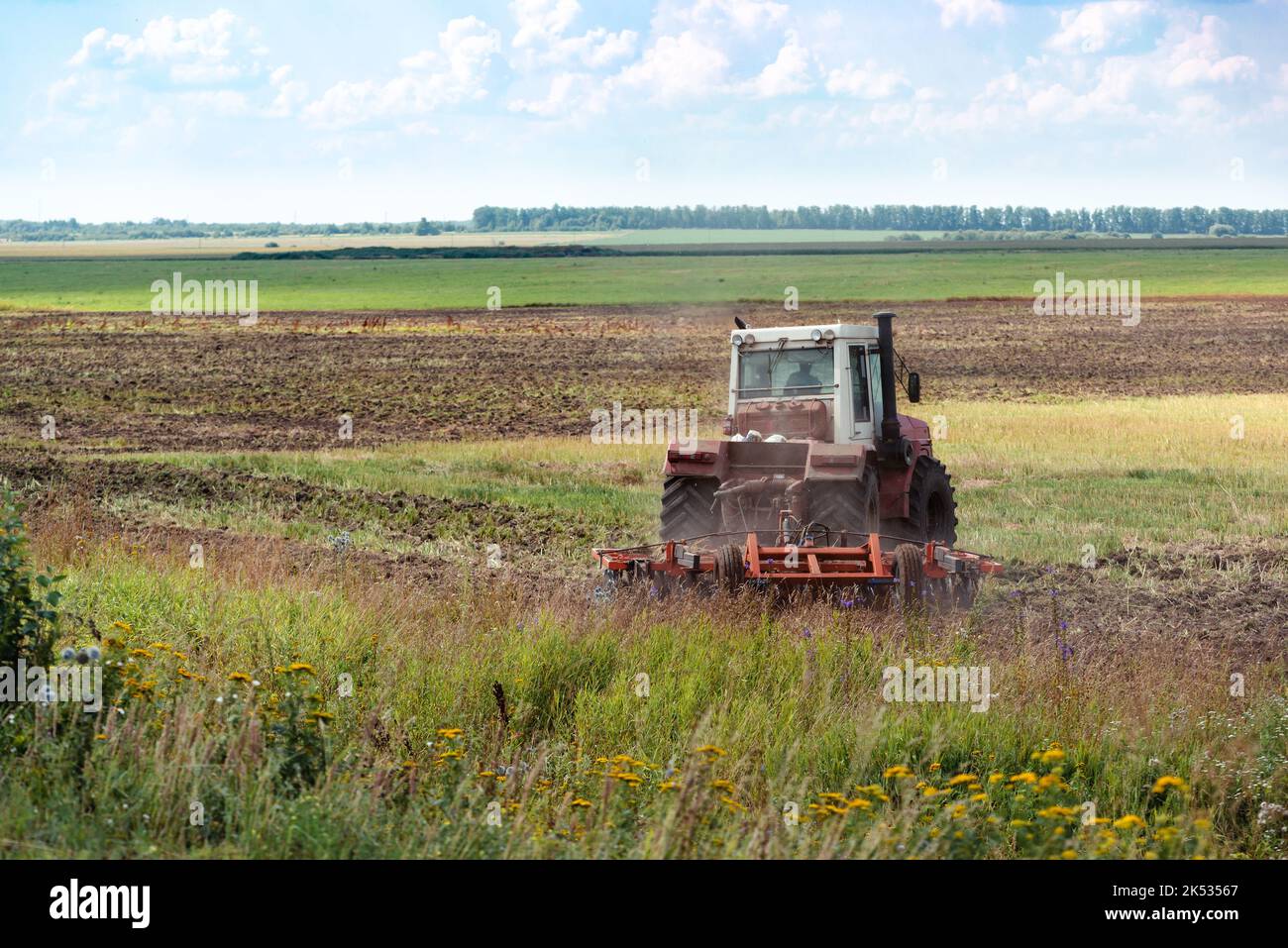 Old farm tractor preparing dusty soil affected by drought. Drought and ...