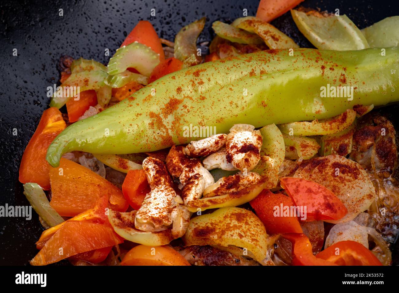 Large chunks of asian vegetables and meat fried in oil with bubbles in ...