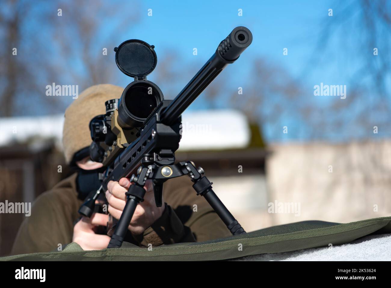 A sniper rifles with an optical sight in man`s hands aiming laying ...