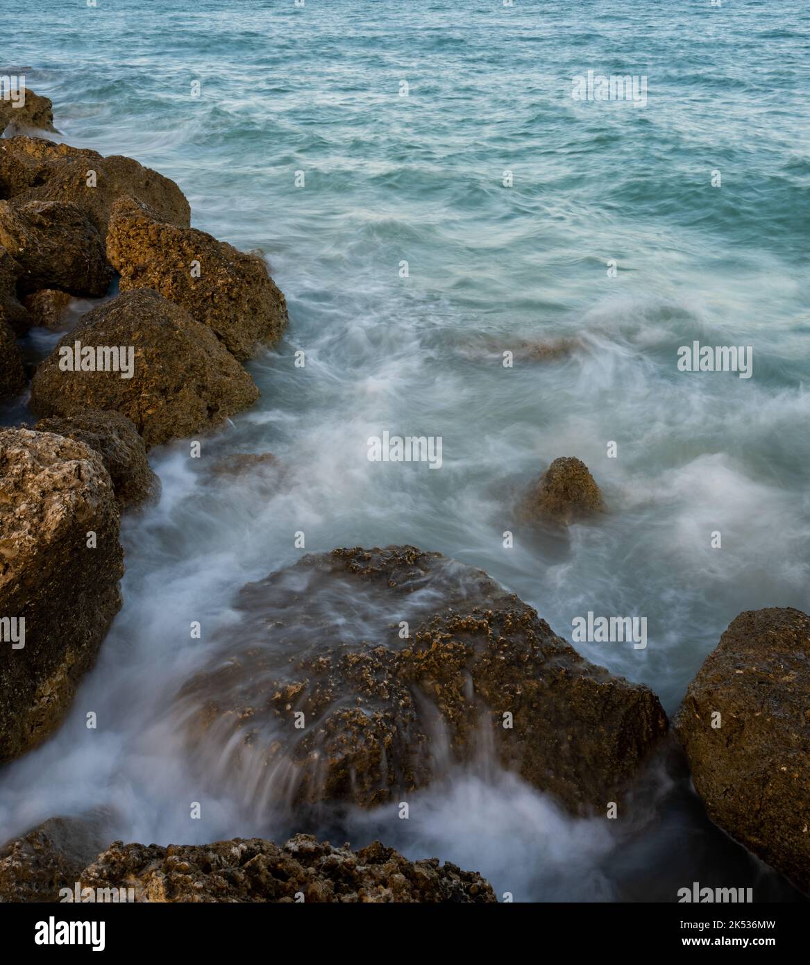 A rocky shore with a wavy sea Stock Photo - Alamy