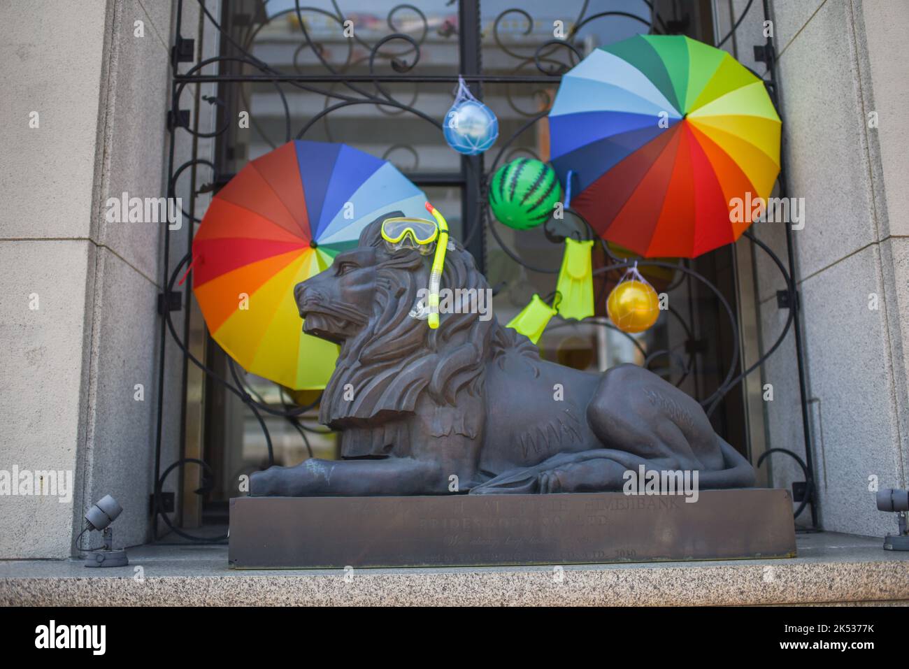 Lion sculpture is decorated with umbrellas and other colorful objects ...