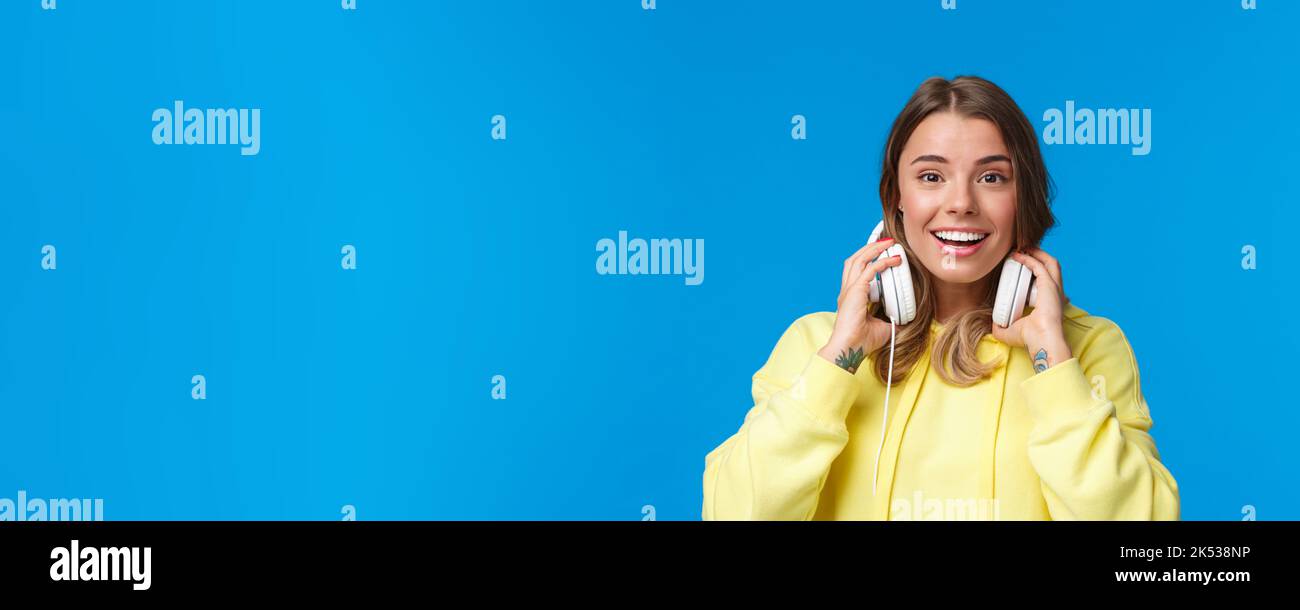 Close-up portrait of excited happy smiling blond girl in yellow hoodie ...