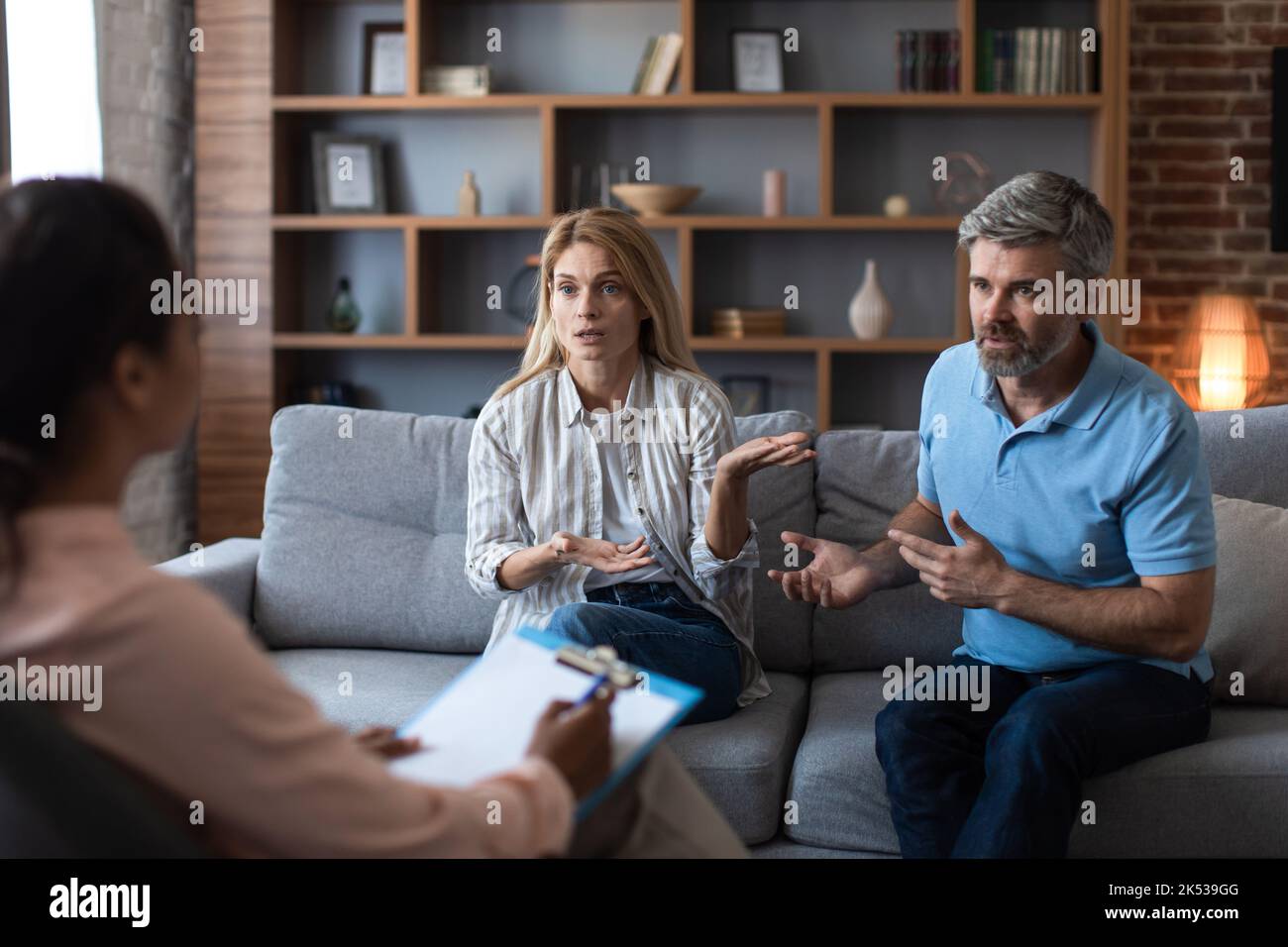 Despaired mature caucasian couple arguing in clinic office interior at ...