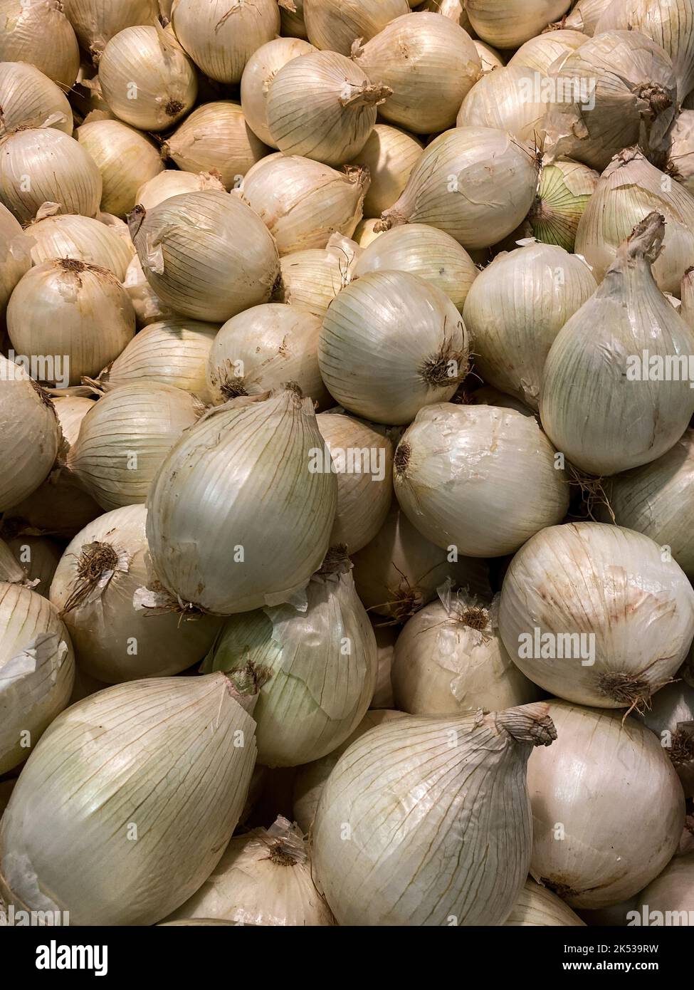 A vertical shot of onions pile in the grocery store Stock Photo - Alamy
