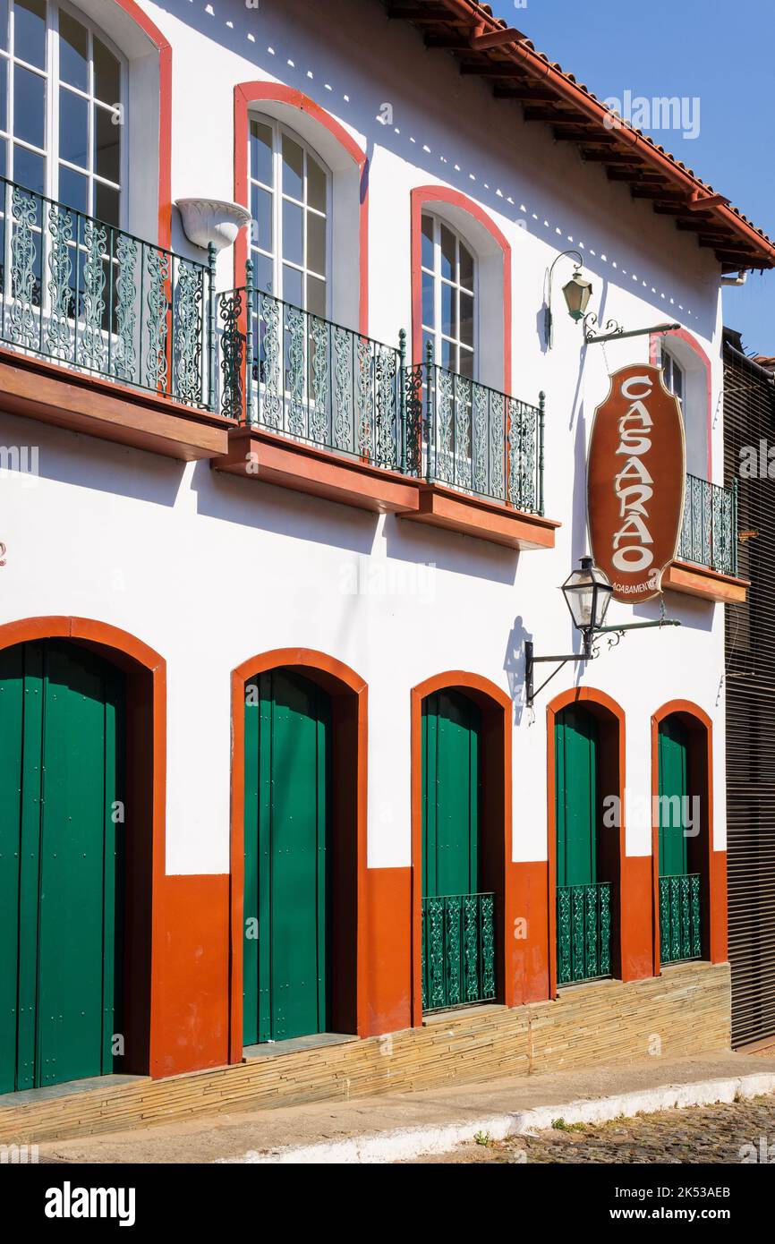 White colonial building with green wooden doors, orange architectural ...