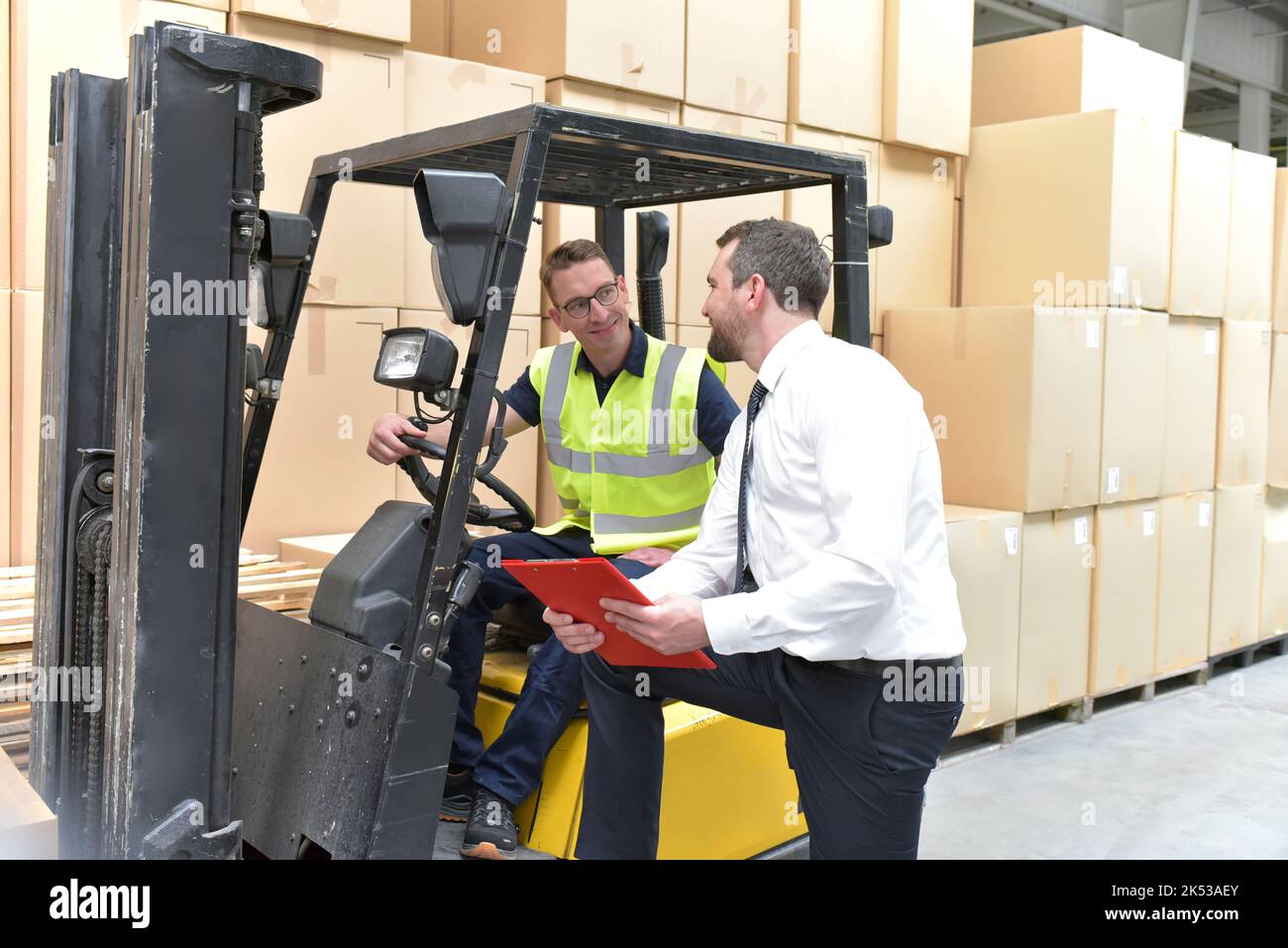 Worker and businessman in a warehouse in the logistics sector ...