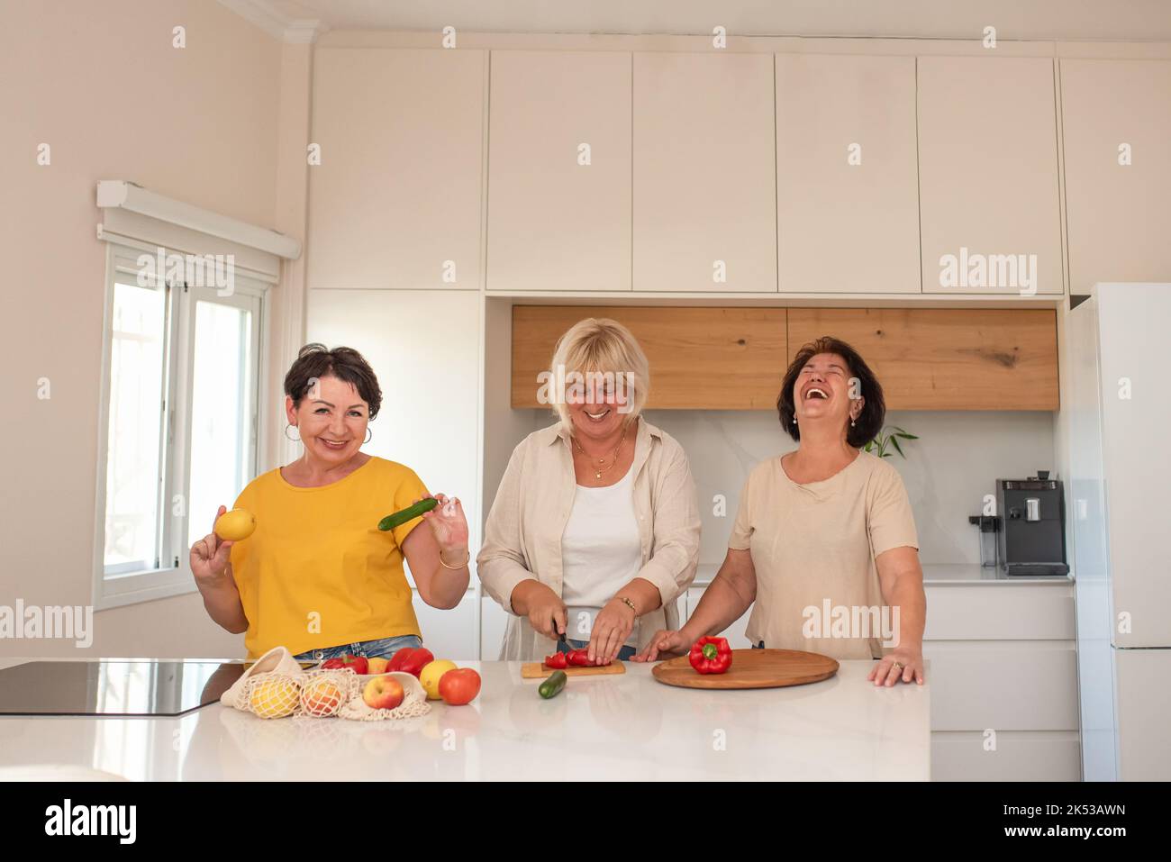 Happy senior women in kitchen cooking together. Mature women in kitchen ...