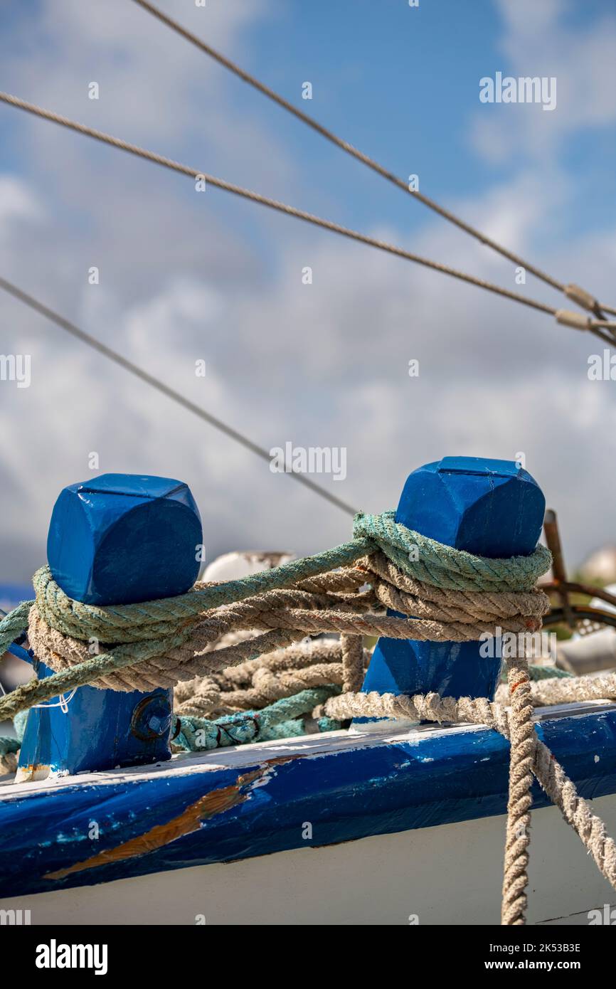nautical themed ropes tied around wooden bollards on old traditional ...