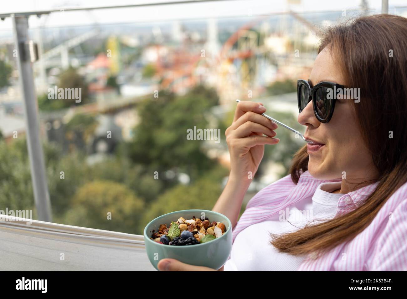 young woman eating chia pudding with nuts and berries Stock Photo - Alamy