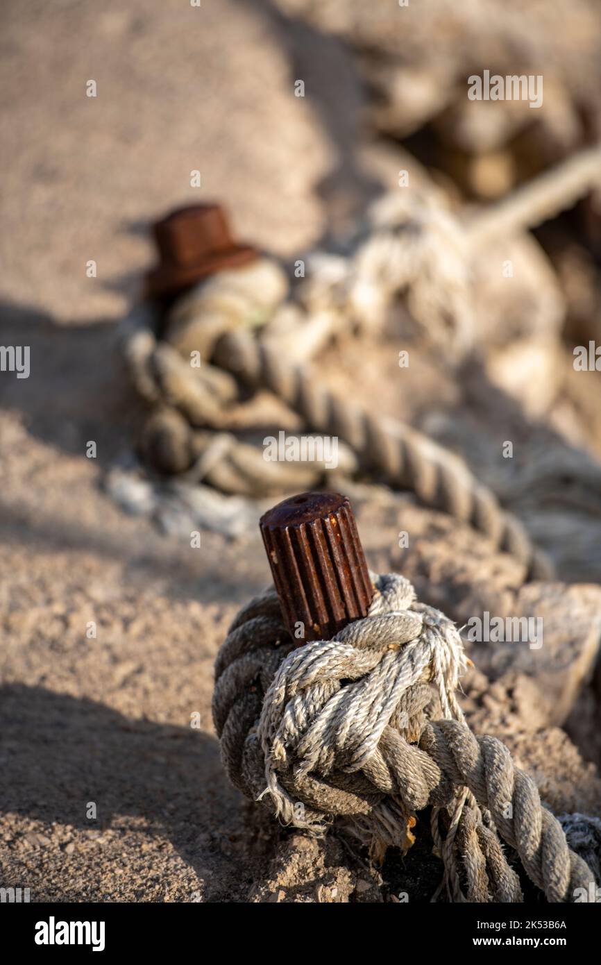 abstract ropes and bollards made from rusty old iron steel pins on a ...