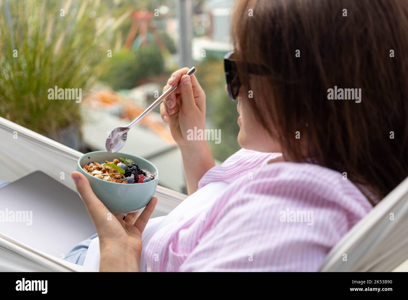 young woman eating chia pudding with nuts and berries Stock Photo - Alamy