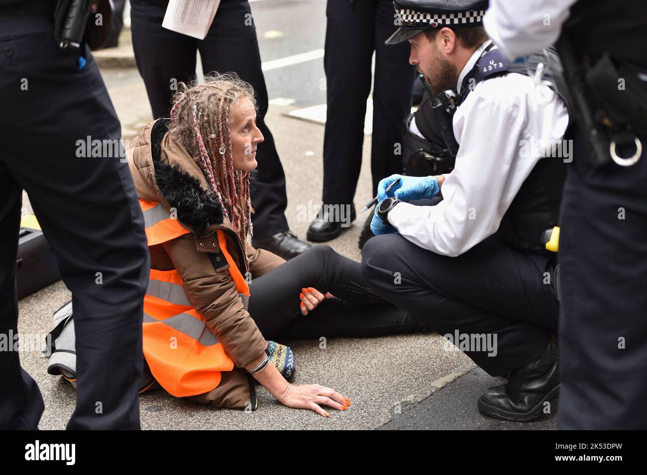 London, UK. 05th Oct, 2022. A protester glued herself to the street in ...