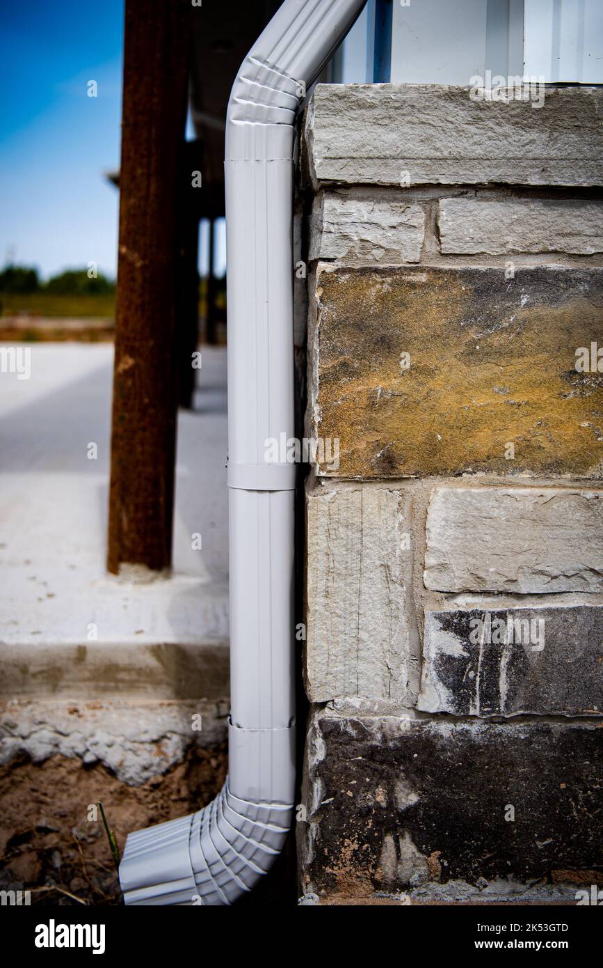 A vertical shot of a silver square labor hanging on a stone building ...