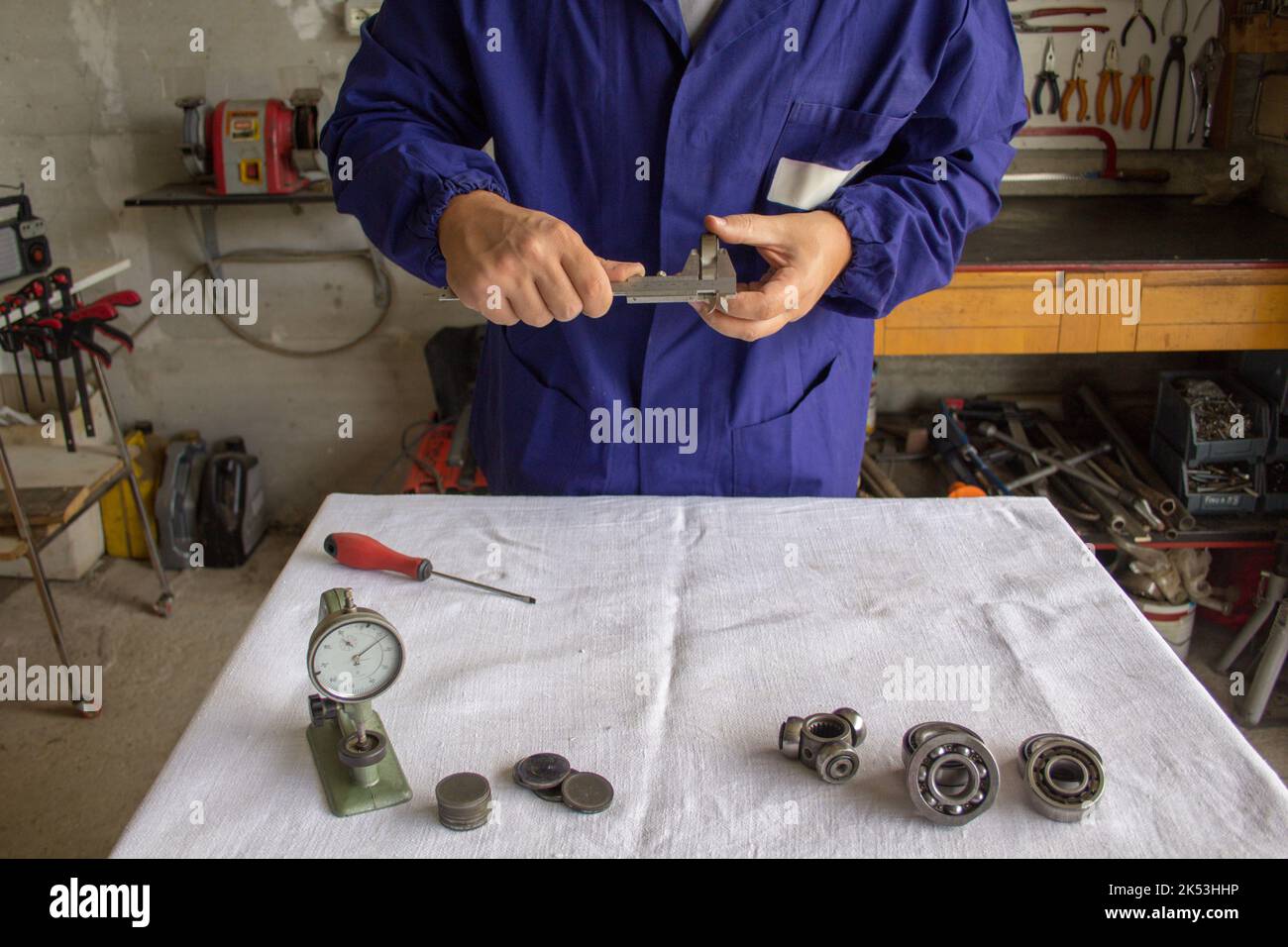 Image of the hands of a mechanic measuring a ball bearing with a ...