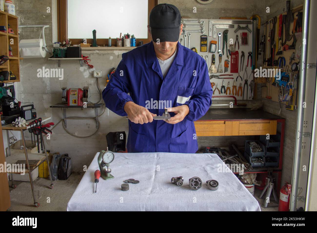 mechanic measuring a toothed pinion of a car transmission. Precision ...