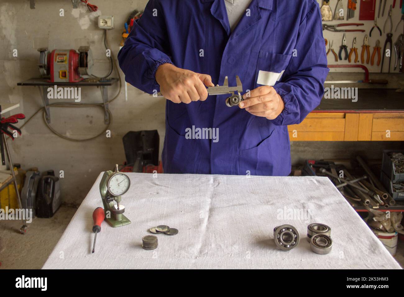 Hands of a mechanic who in his workshop measures a car cross with a ...