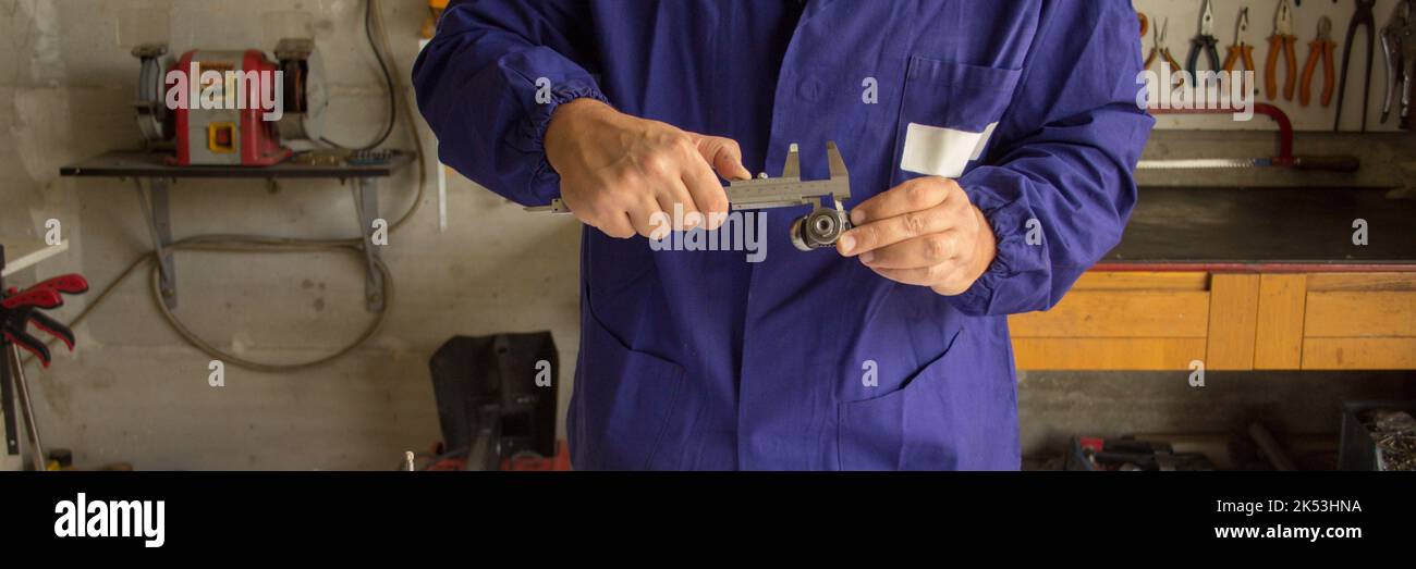 Hands of a mechanic who in his workshop measures a car cross with a ...