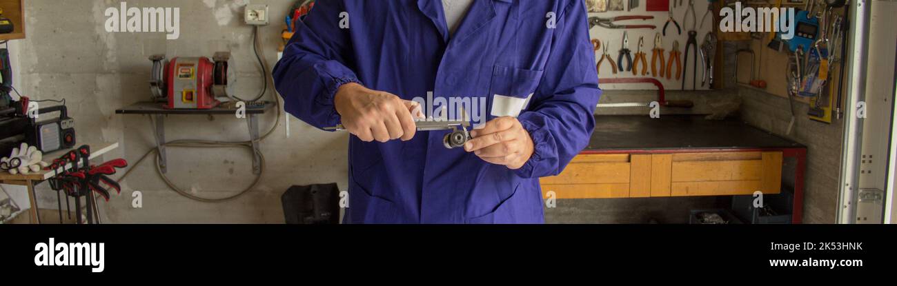 Hands of a mechanic who in his workshop measures a car cross with a ...