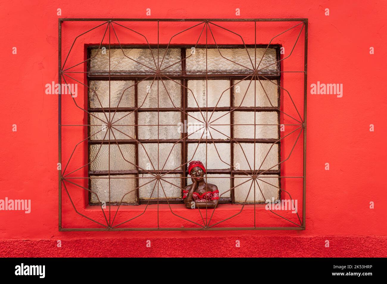 Red wall with brown window and window grill and baiana statue in ...