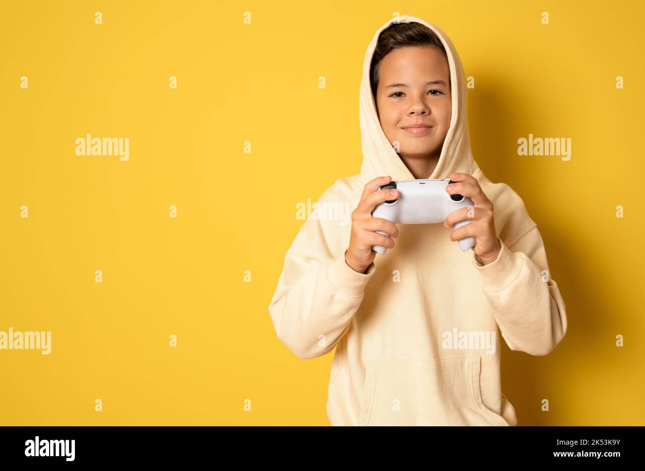 A young child having fun playing video games standing isolated over ...