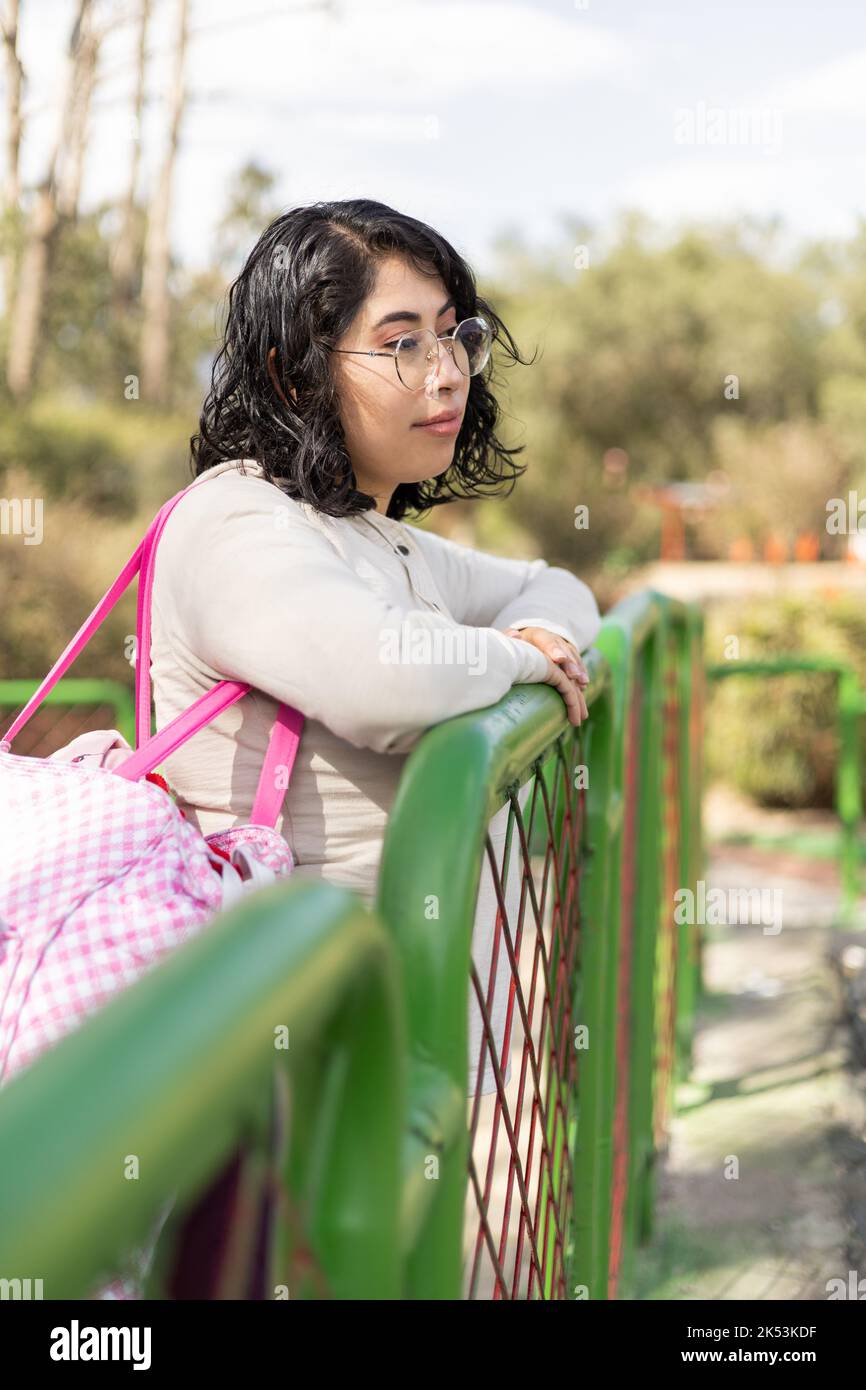 relaxed young latin woman with short wavy hair wearing glasses and a ...