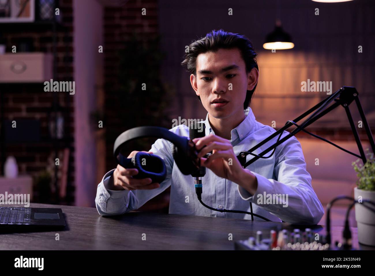 Male vlogger reviewing headphones on livestream, filming podcast video ...